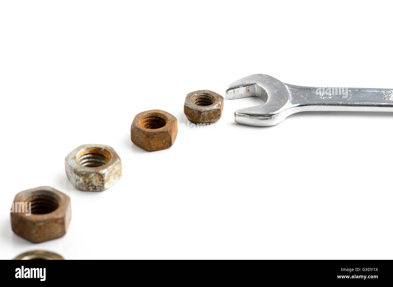 Steel wrench key and many rusted nuts isolated on white background ...