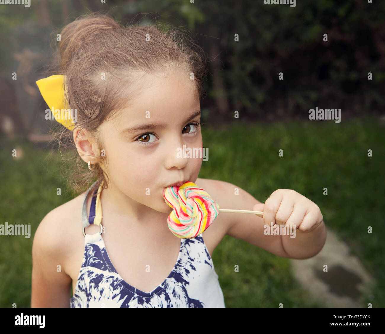 Little girl eating lollipop Stock Photo - Alamy