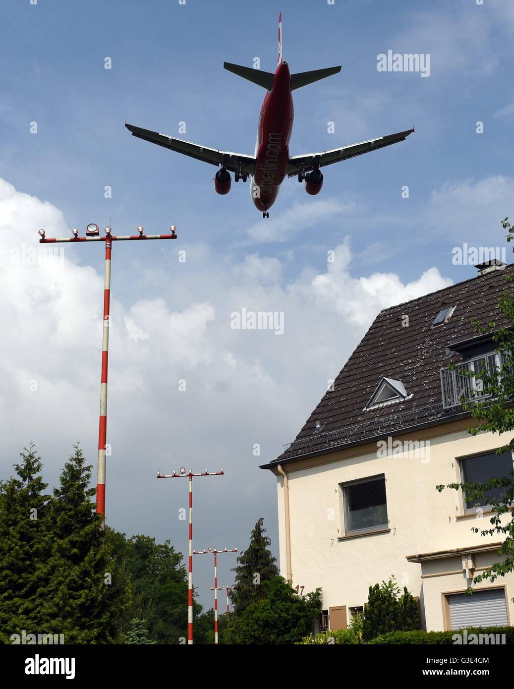 An airplane next to the roof of a residential building is about to land ...