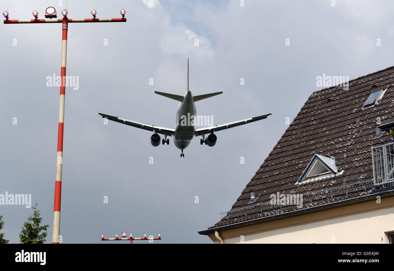 An airplane next to the roof of a residential building is about to land ...