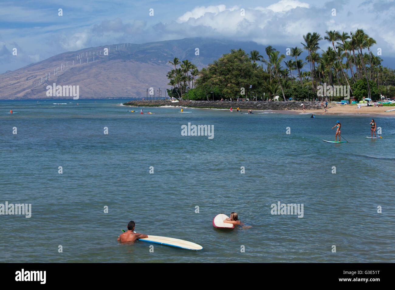 Surfers, stand up paddlers, Cove Park Beach, West Maui Mountains in the ...