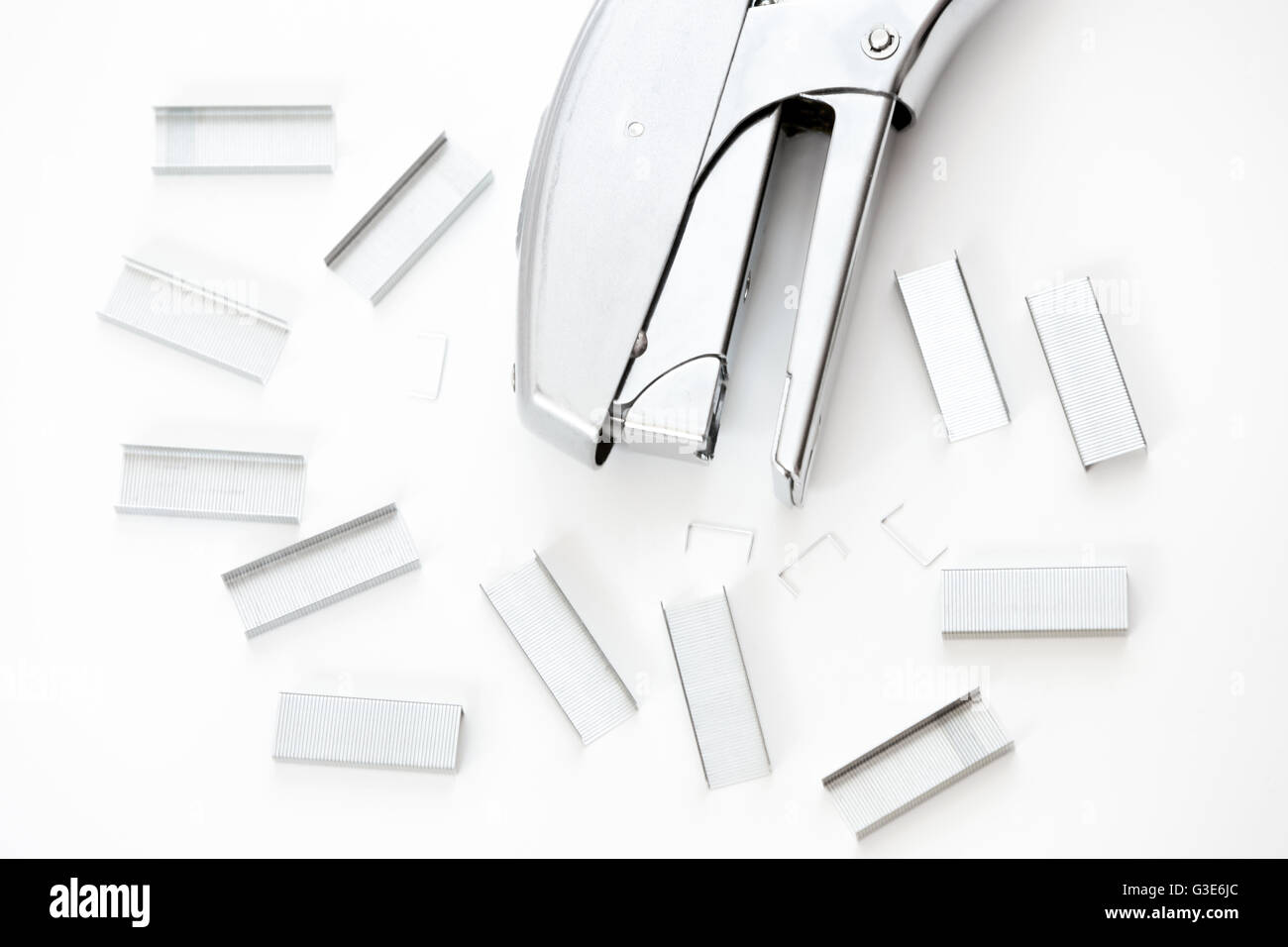 A top view of a staple and a group of staples arranged on white ...