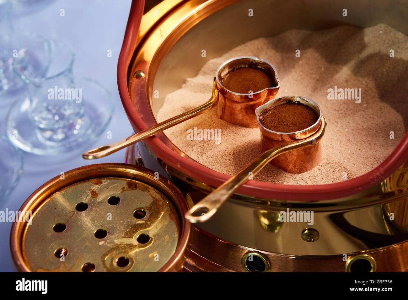 Preparation of Turkish coffee in the cezve in the sand at cafe bar ...