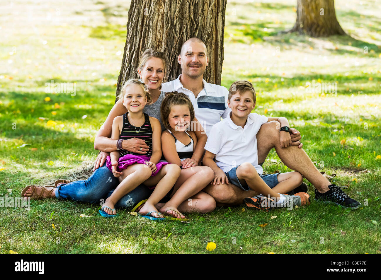 A family posing for a family portrait in a park; Edmonton, Alberta ...