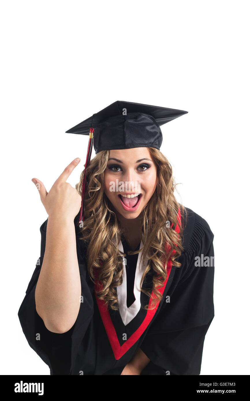 Young graduating woman pointing at her grad cap in celebration ...