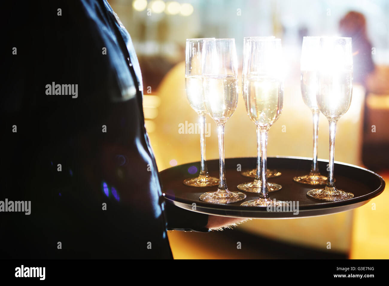Waiter serving champagne on a tray Stock Photo - Alamy