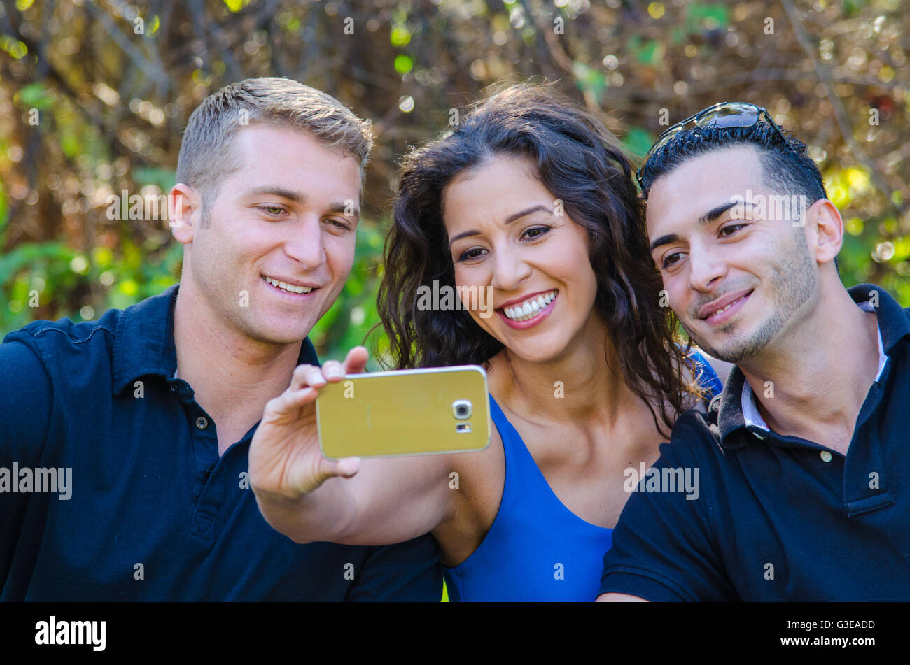Mixed race friends smiling at cell phone image outside Stock Photo - Alamy