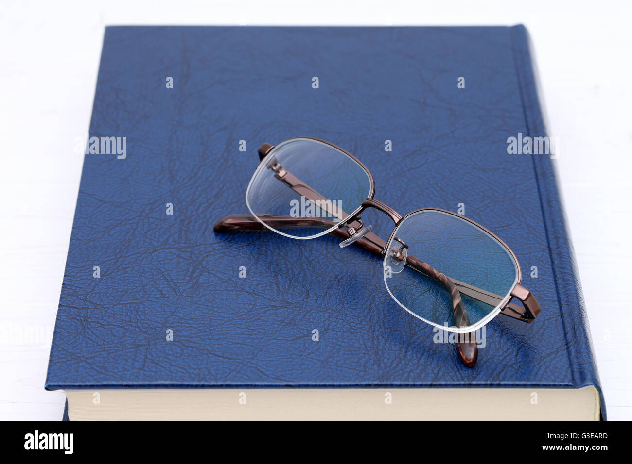 Glasses and book on the white wooden table Stock Photo - Alamy