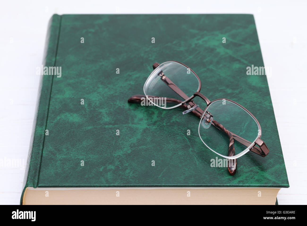 Glasses and book on the white wooden table Stock Photo - Alamy
