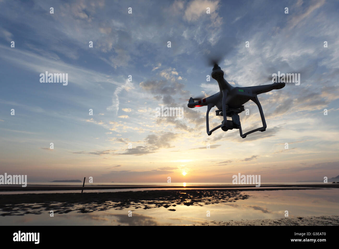 Drone flying against a sunset sky Stock Photo - Alamy