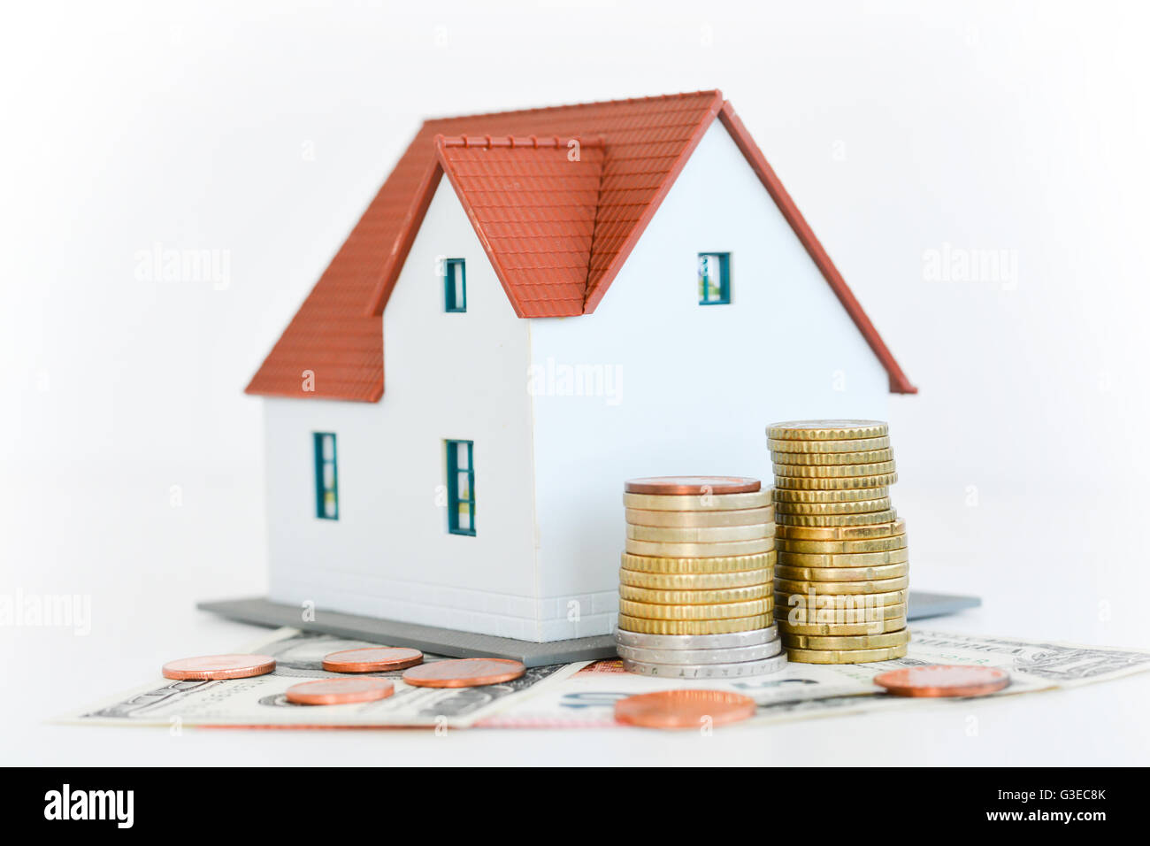 Classic home model with pile of coins isolated on white background ...
