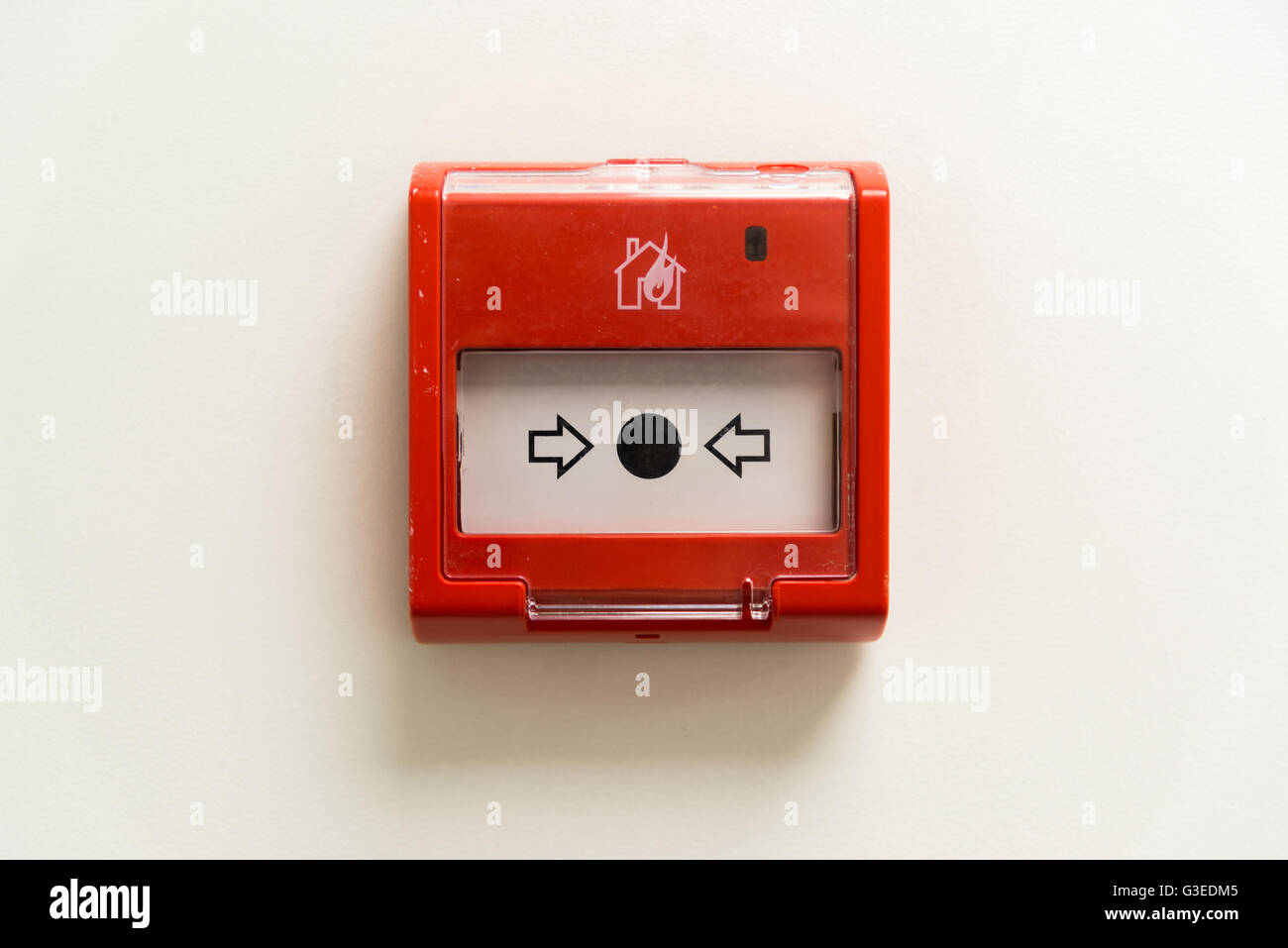 Red fire button on the light wall Stock Photo - Alamy