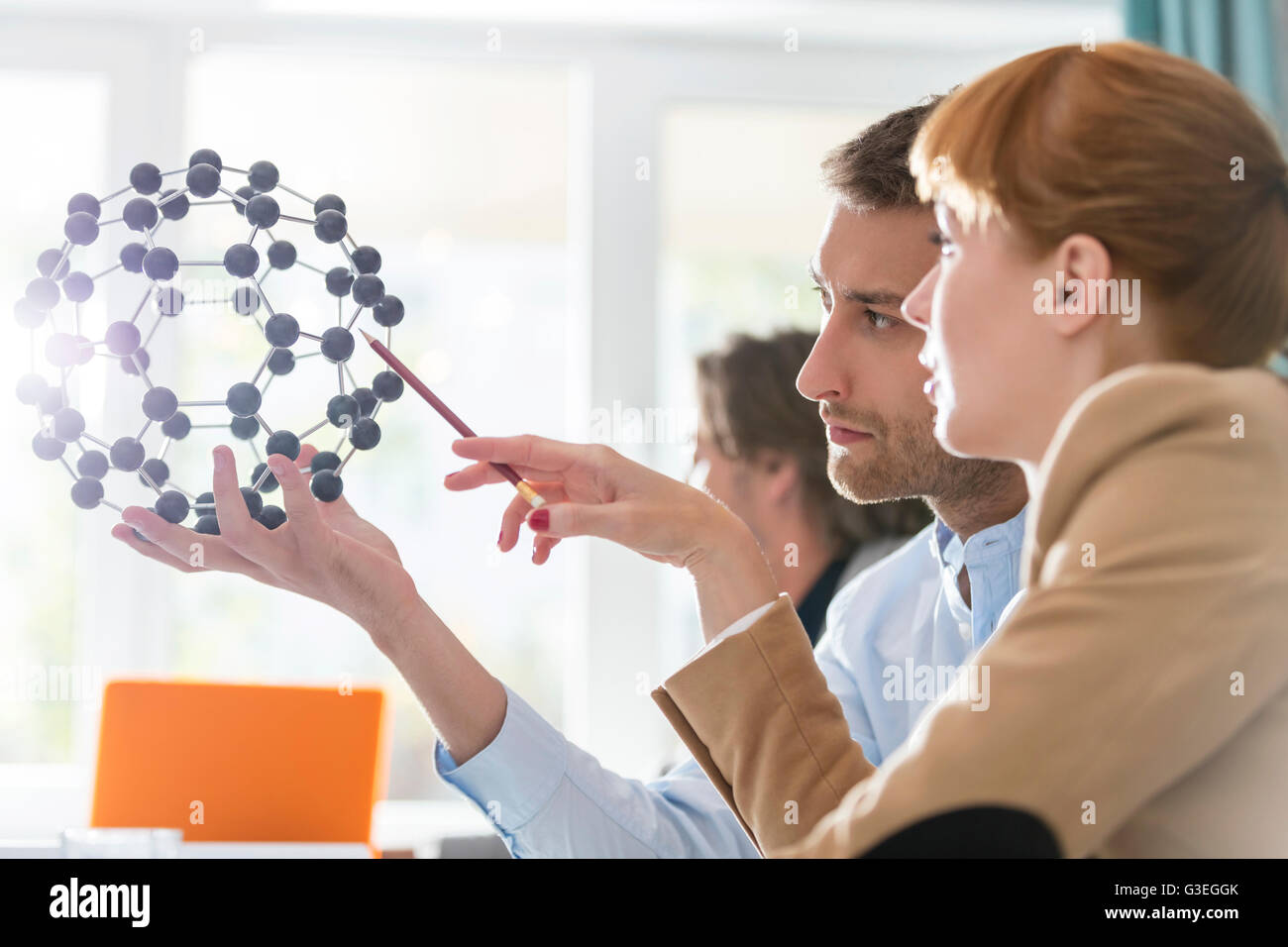 Innovative business people examining model in meeting Stock Photo - Alamy