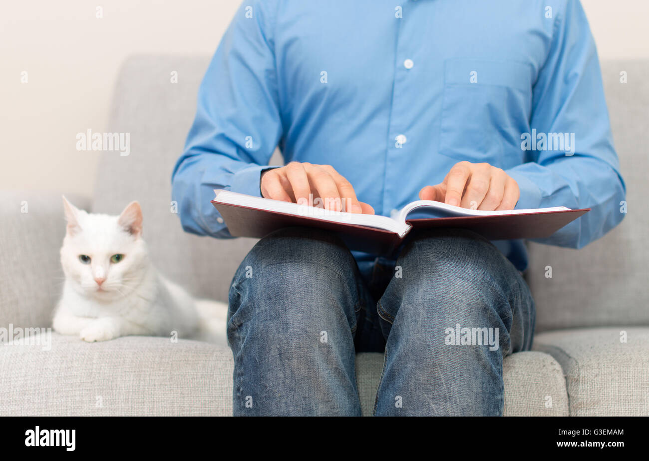 Blind man reading braille book on the couch Stock Photo - Alamy