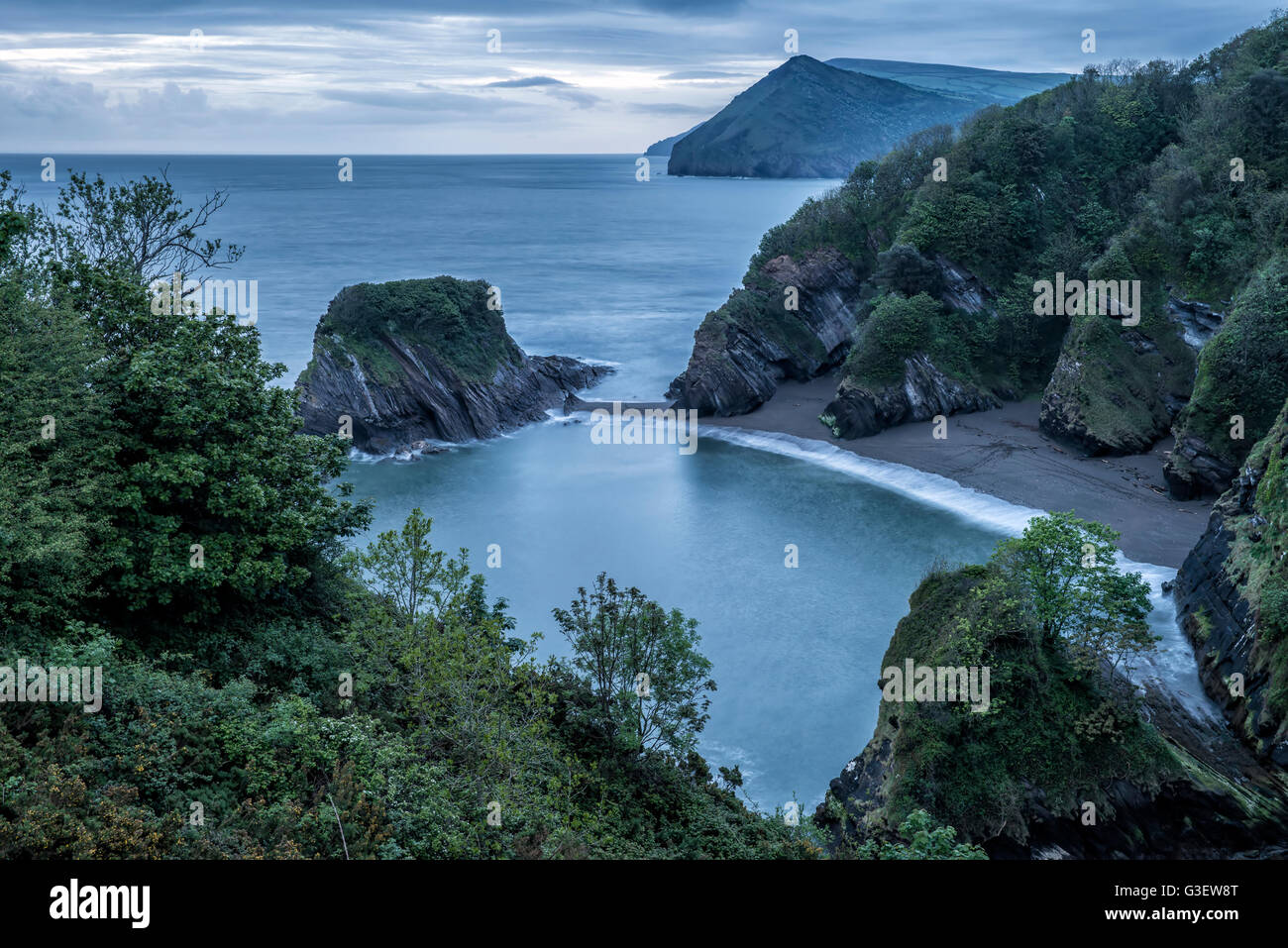 Beautiful moody sunrise landscape image of small secluded cove at Combe ...