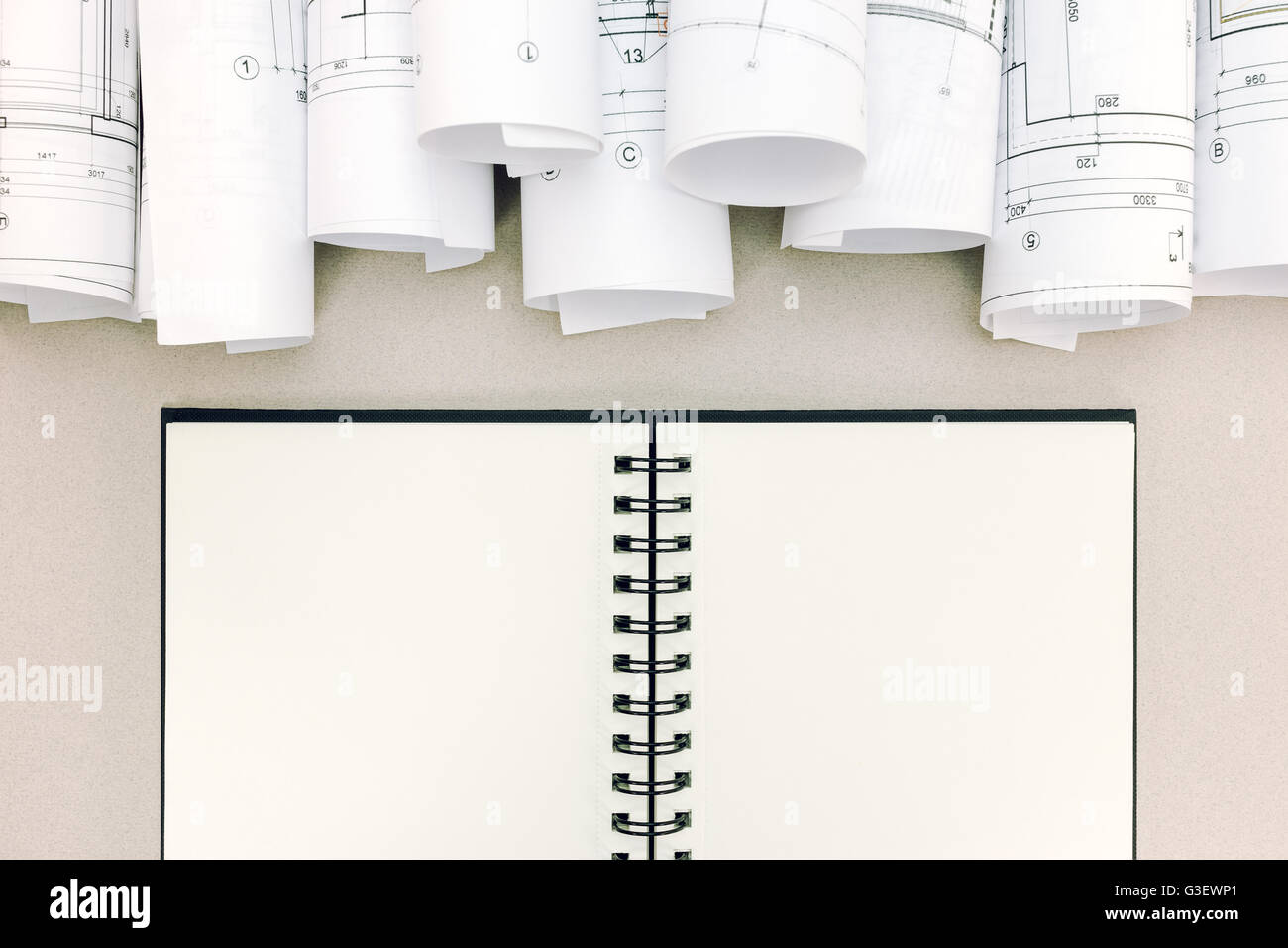 rolls of architectural blueprints and technical drawings with notepad ...