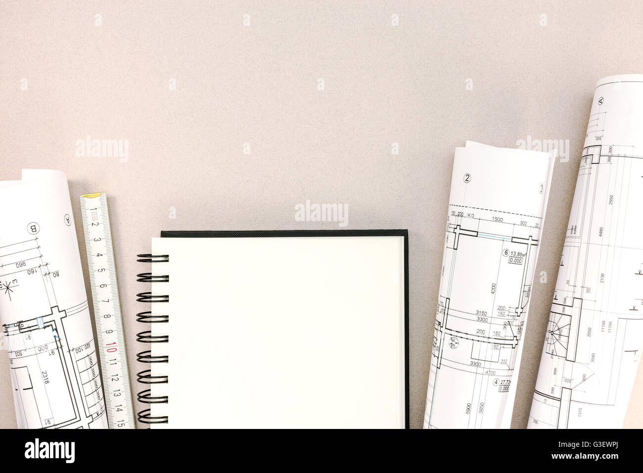 rolls of architectural blueprints with notepad and folding rule top ...