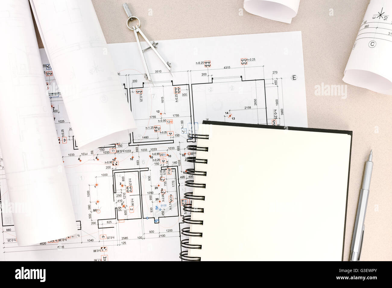 architect workspace with blueprints, rolls, notepad, drawing compass ...