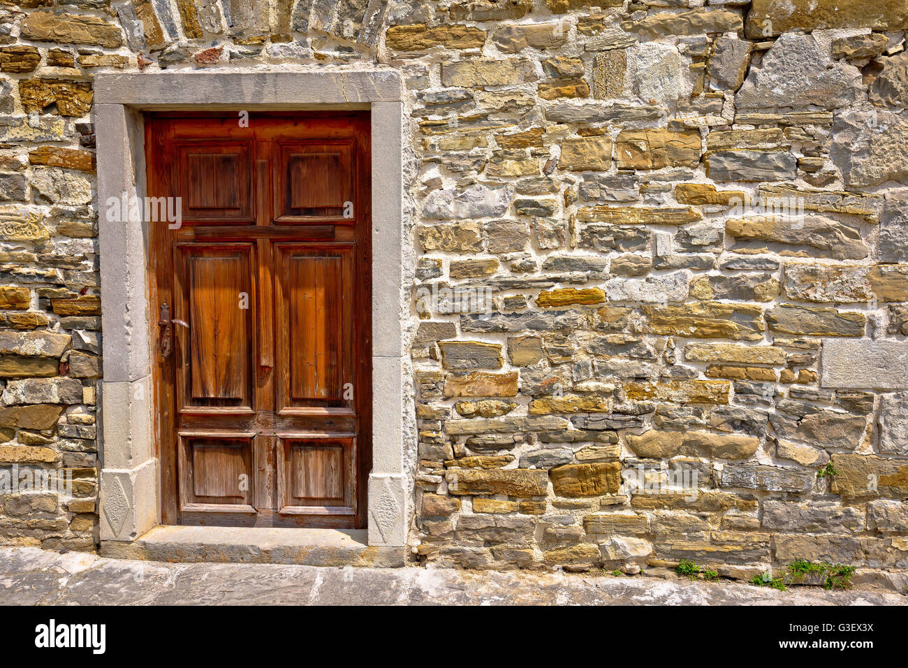 Mediterranean style wooden door on stone wall, architecture detail view ...