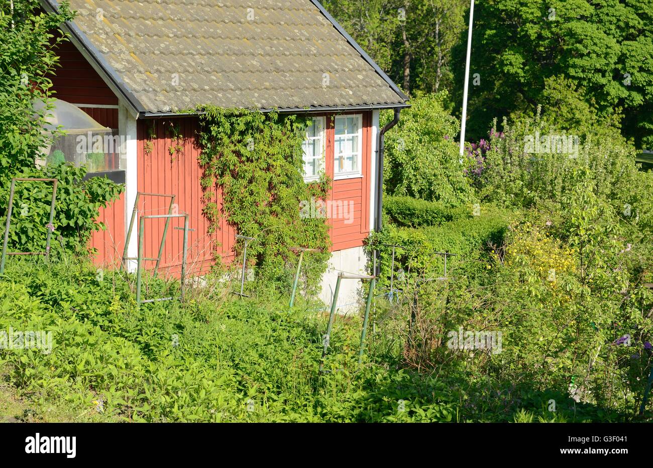Idyllic red cottage in botanical garden Stock Photo - Alamy