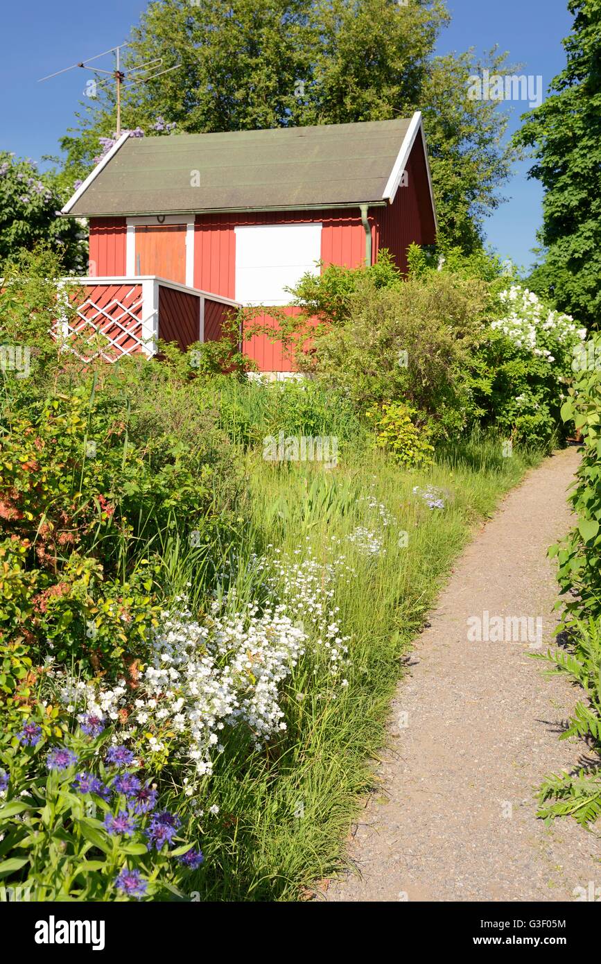 Idyllic red cottage in botanical garden Stock Photo - Alamy
