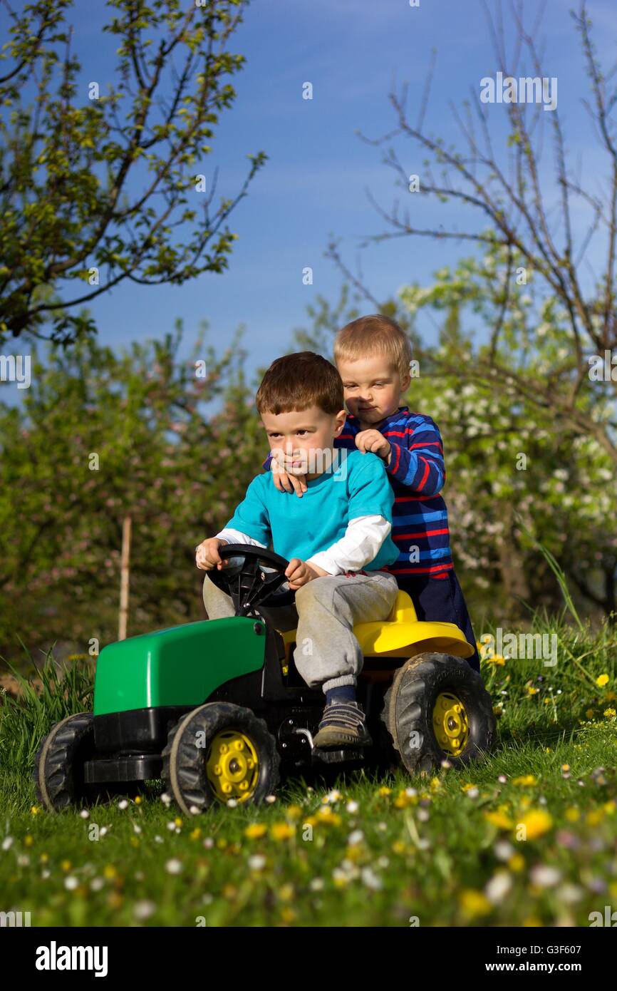 Two little boy sits in a baby tractor Stock Photo - Alamy