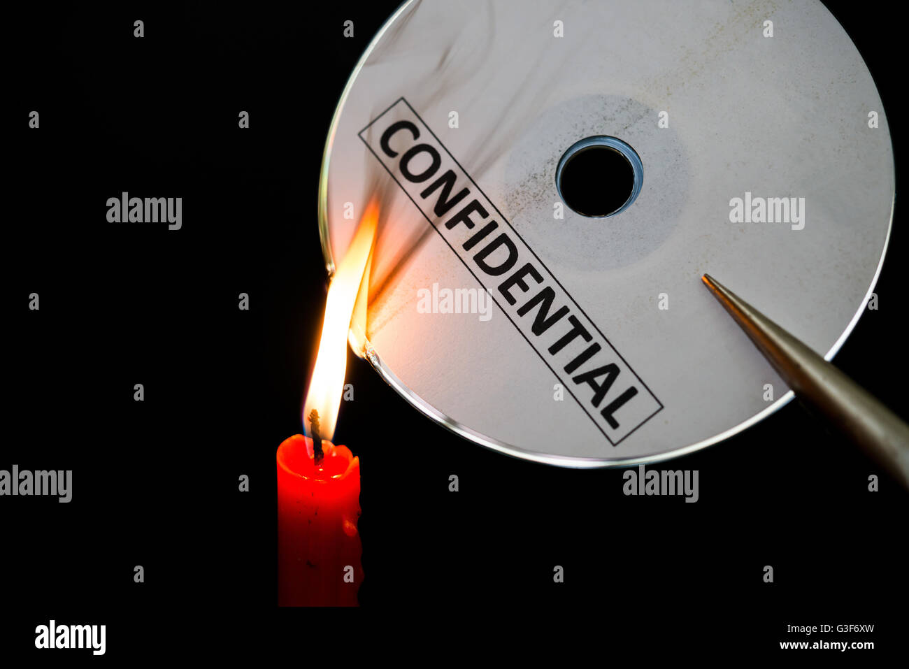 burning a confidential compact disc with candle in dark Stock Photo - Alamy