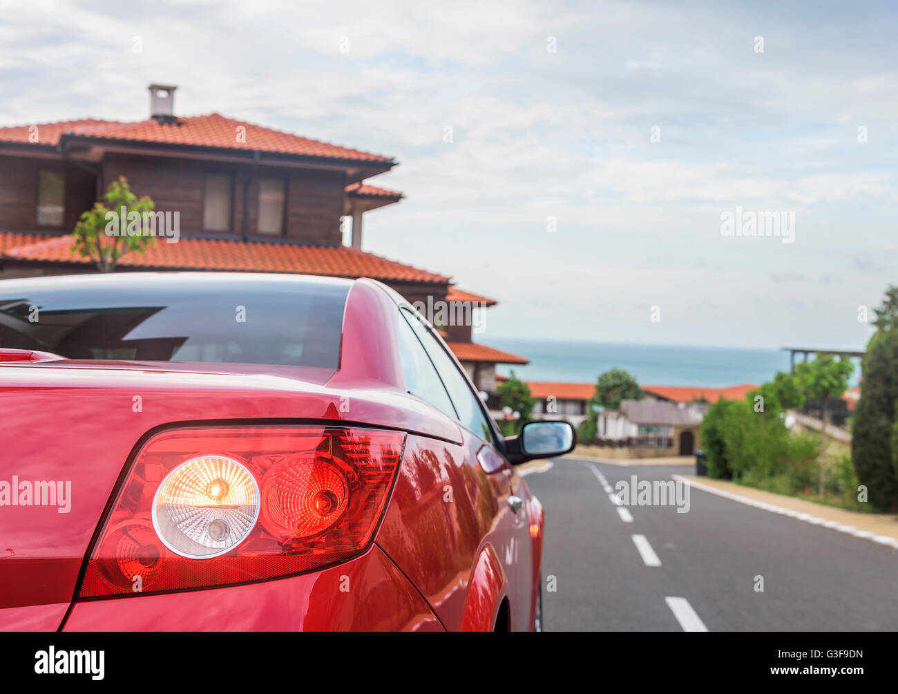 Red car on city streets in a beautiful well-groomed road Stock Photo ...