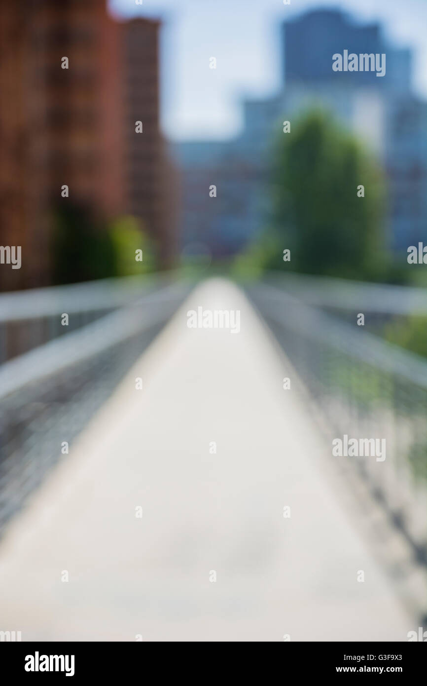 Unfocused blurred view on bridge and summer alley, in city setting ...