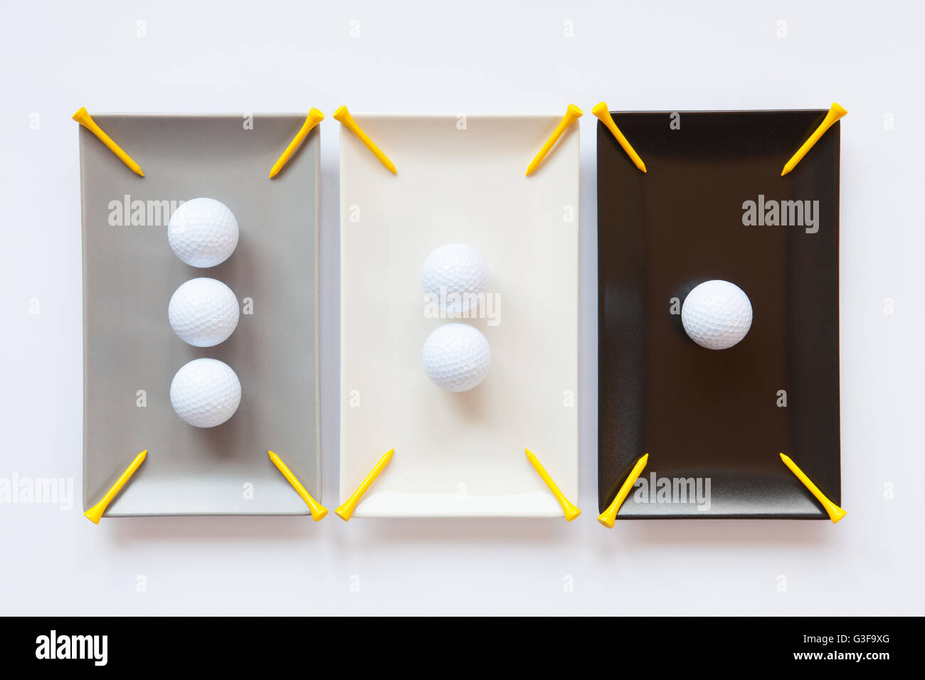 Different ceramic dishes with golf balls on over white background ...