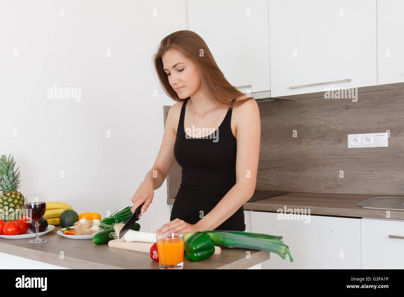 Portrait of a beautiful young smiling woman. Young girl cooking in the ...