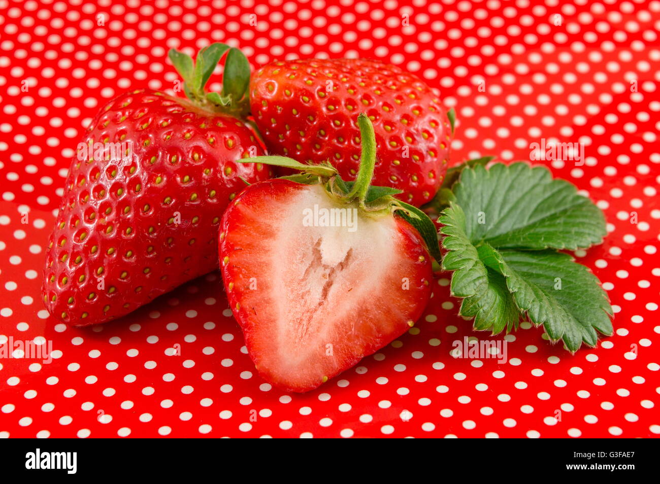 Fresh red strawberries on a red dotted background Stock Photo - Alamy