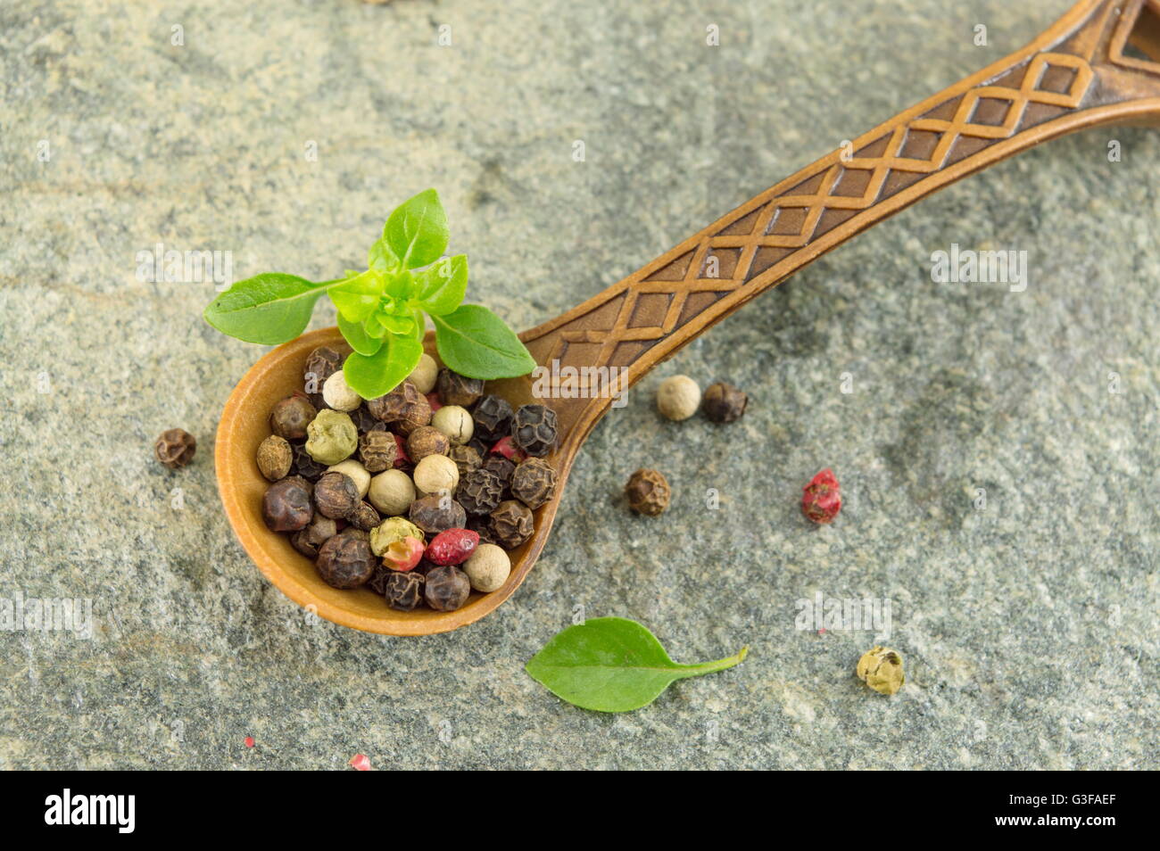 pepper spice grains in a wooden spoon on a stone table Stock Photo - Alamy