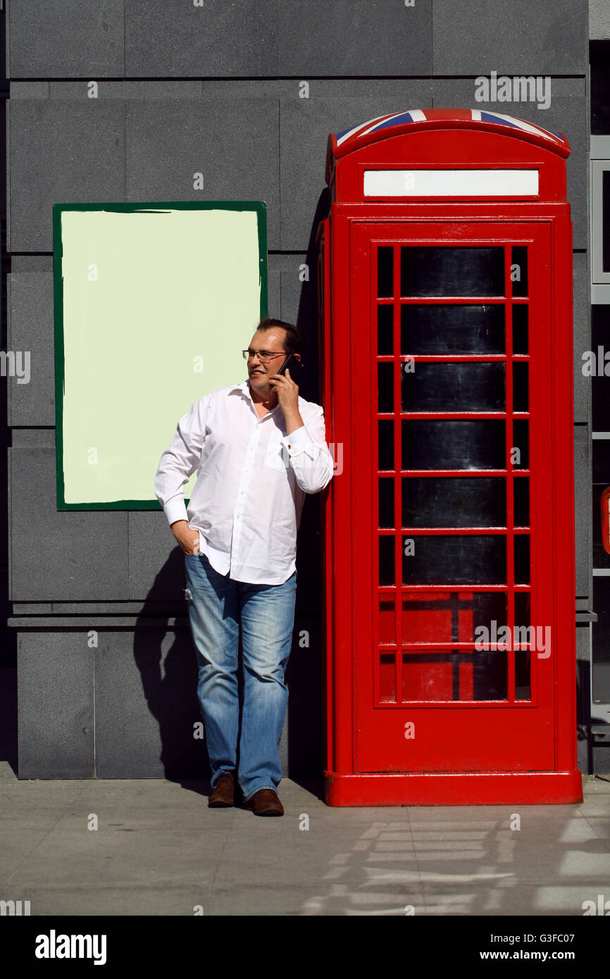 Business man using mobile phone red classic English telephone box Stock ...
