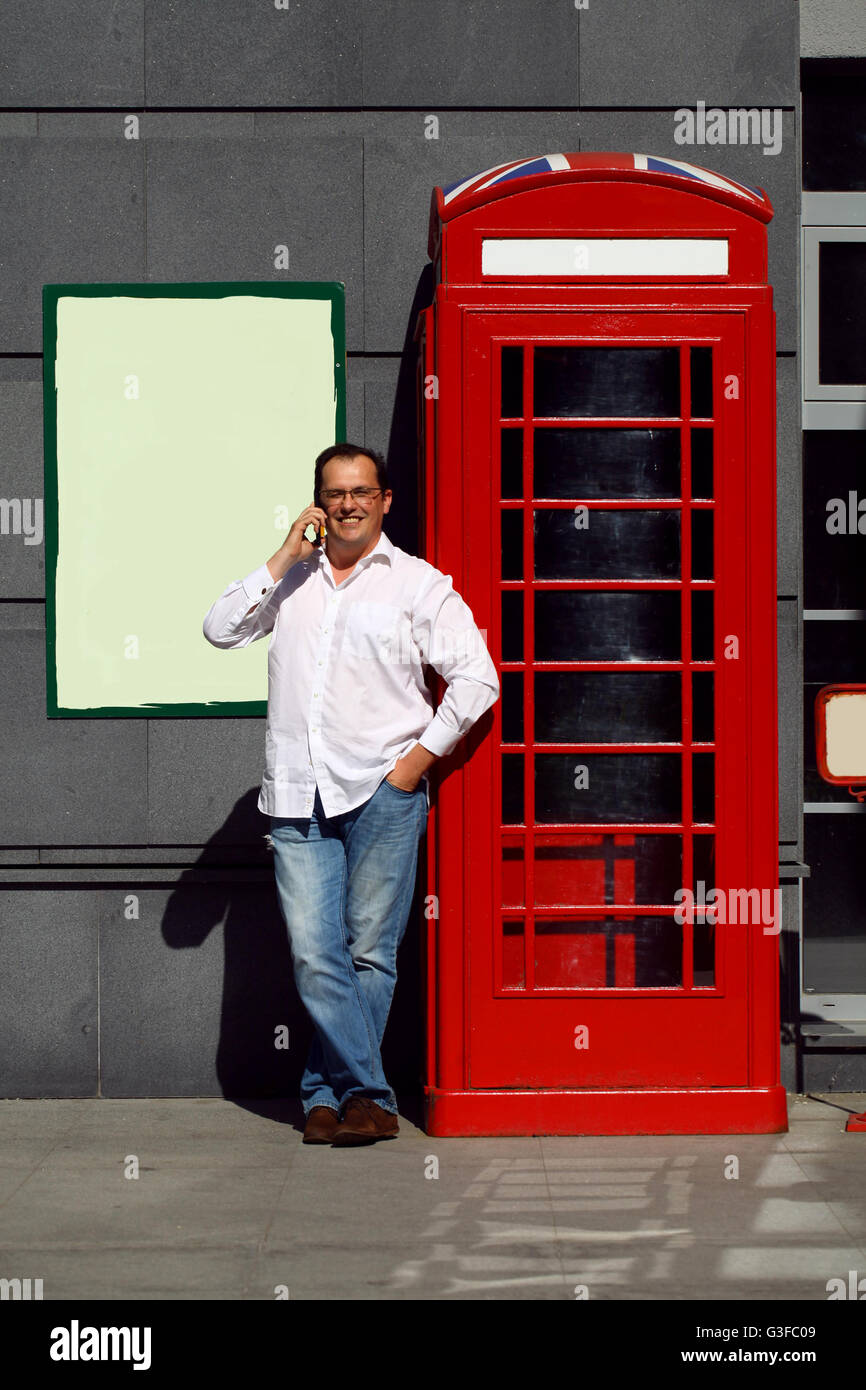 Business man using mobile phone red classic English telephone box Stock ...