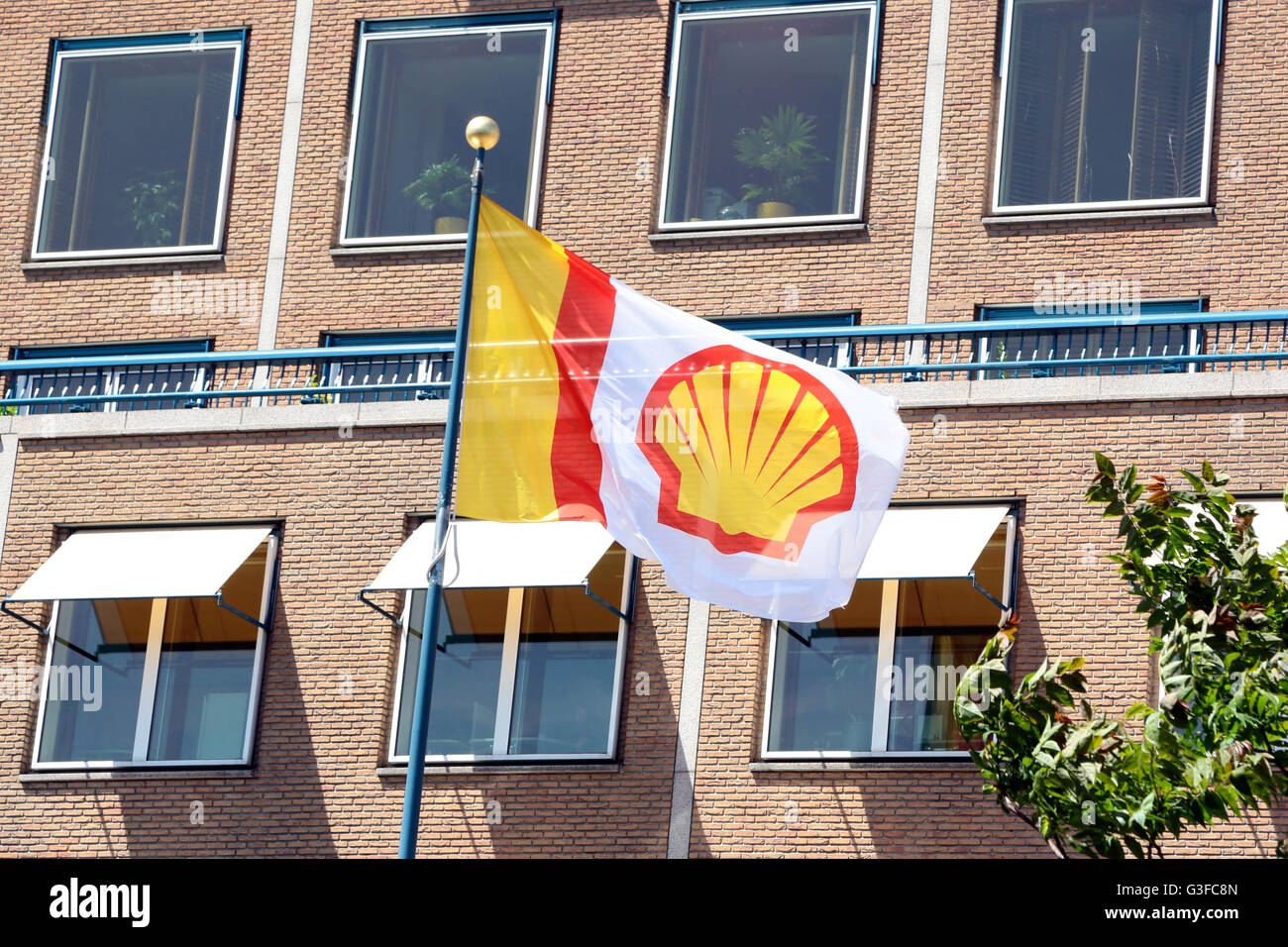 Flag with the logo of Royal Dutch Shell in front of the head office in ...