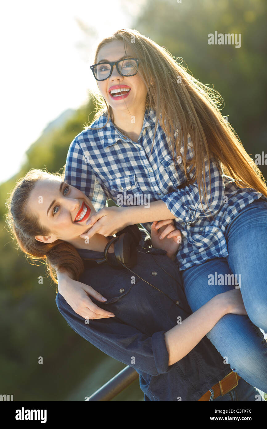 Two playful young women having fun outdoors at sunset light Stock Photo - Alamy