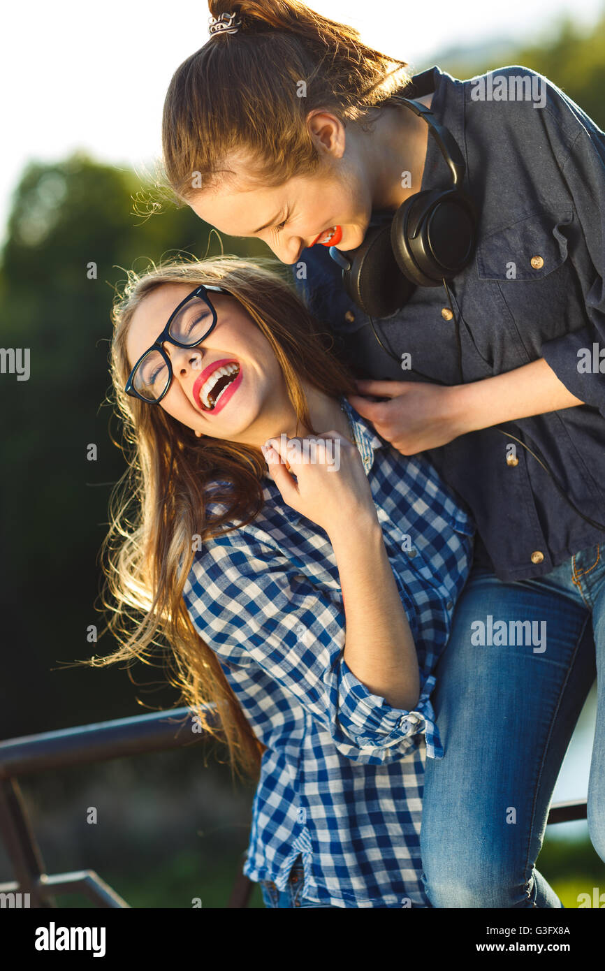 Two playful young women having fun outdoors at sunset light Stock Photo ...