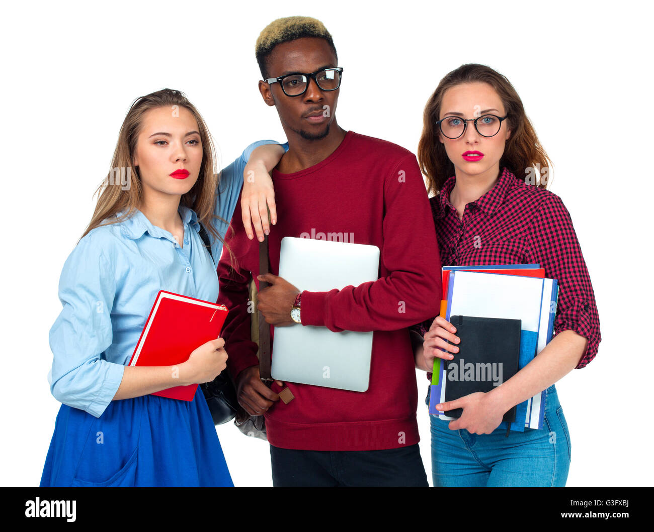 Three happy young teenager students with books, laptop and bags ...