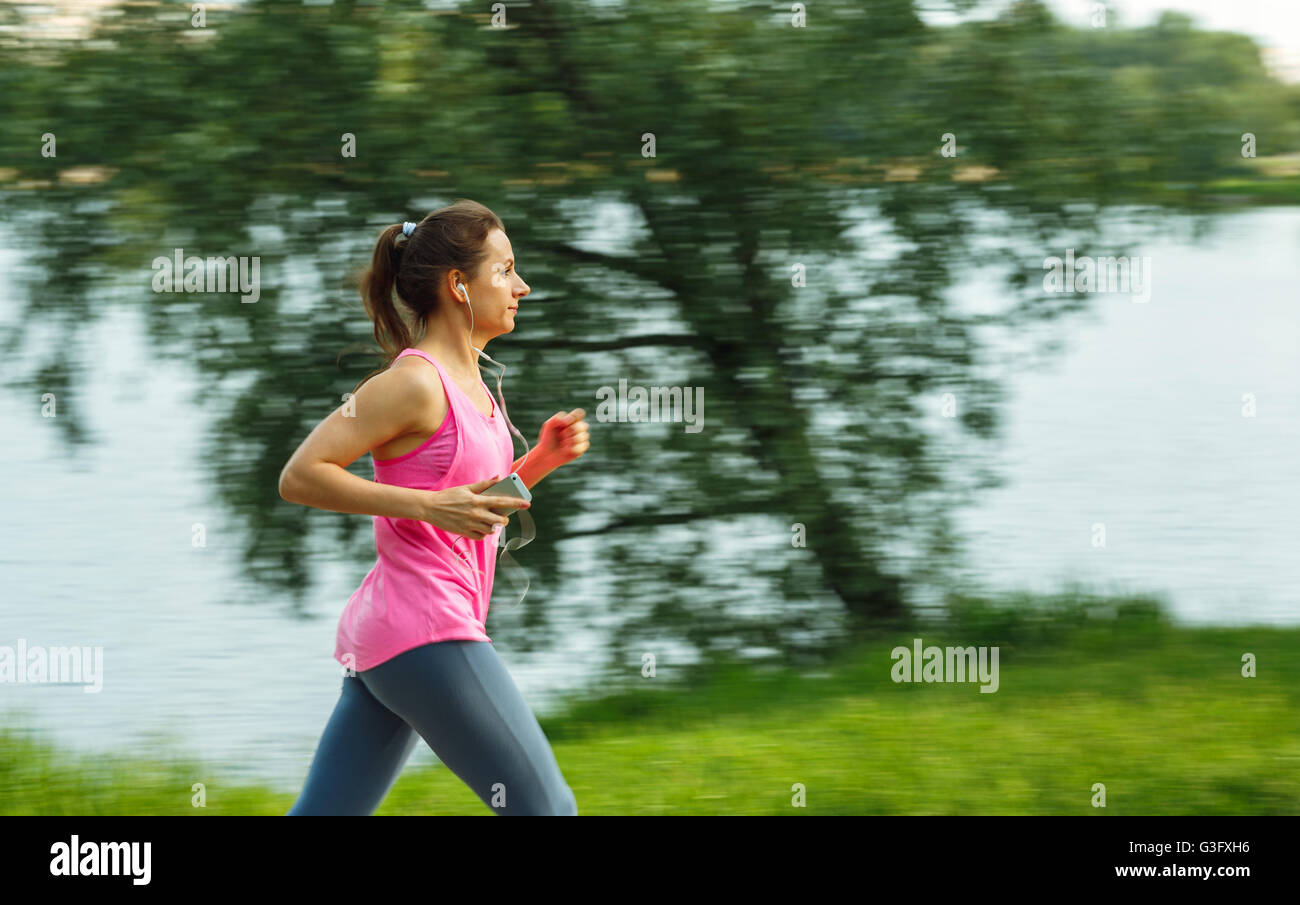 Young fitness woman runner running on trail in the morning Stock Photo - Alamy