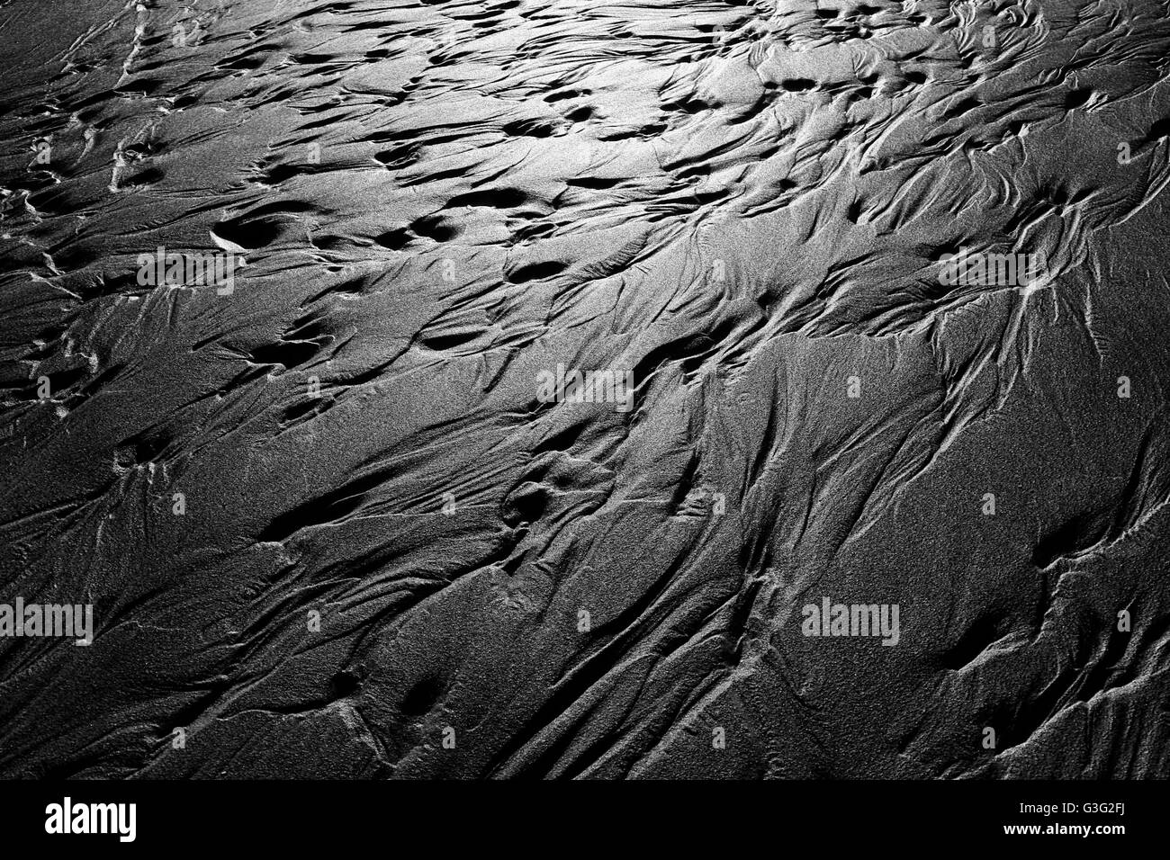 High contrast black and white rivulets on a sandy beach Stock Photo - Alamy