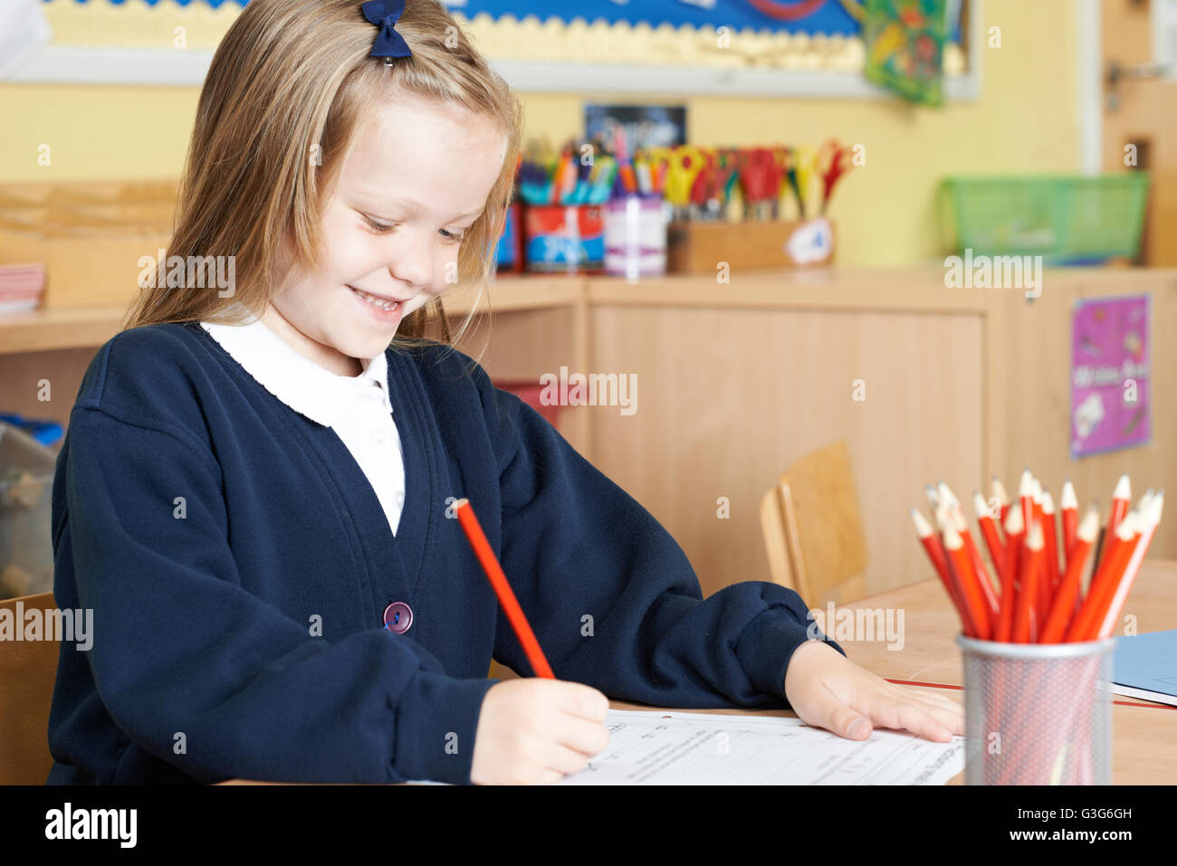 Female Elementary School Pupil Working At Desk Stock Photo - Alamy
