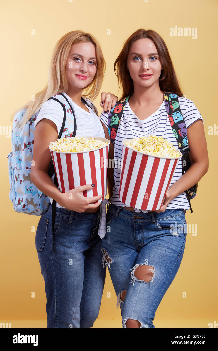 two cheerful girls eat popcorn from huge bowl Stock Photo - Alamy