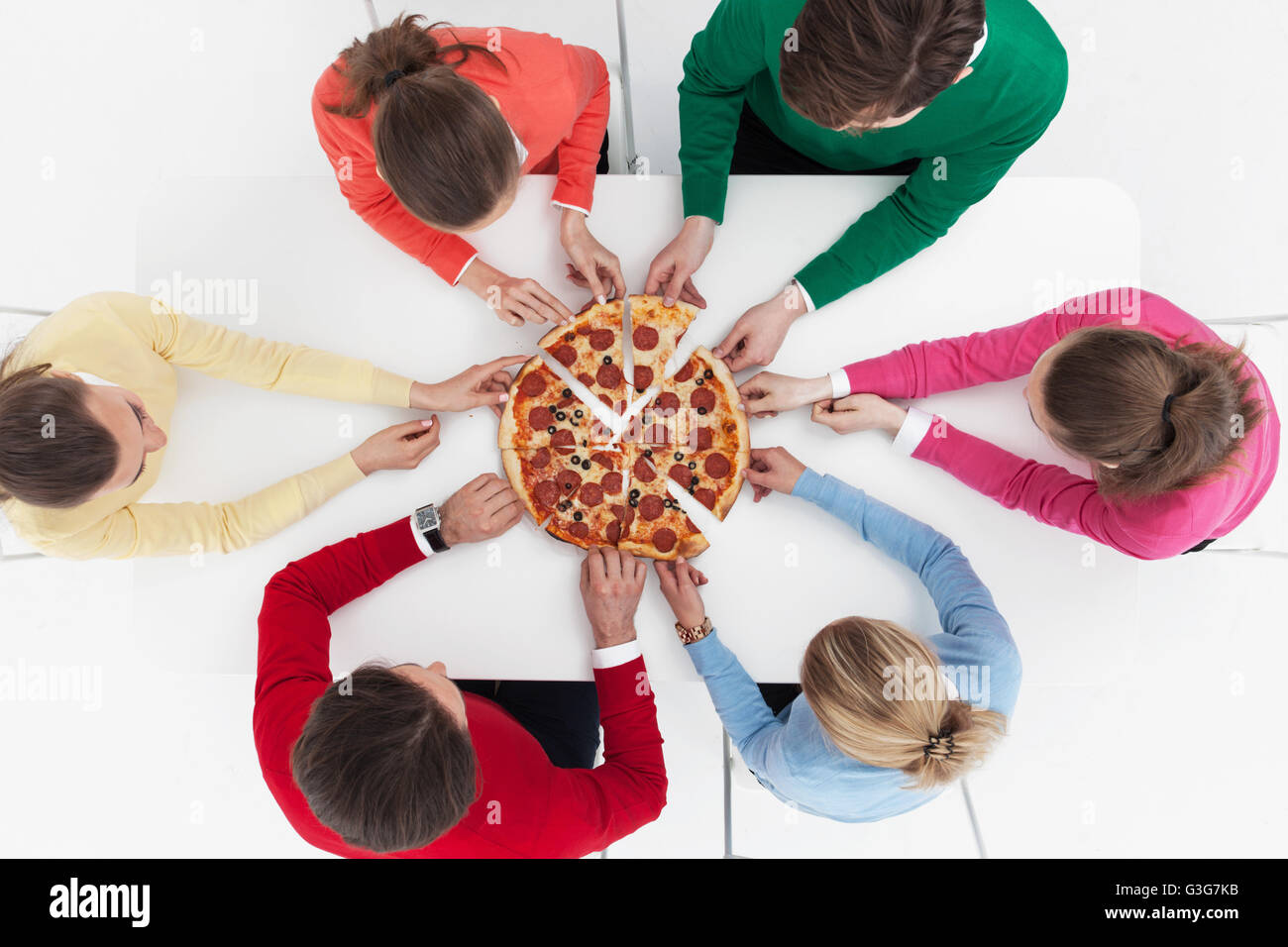 Top view of people sitting around the table with pizza Stock Photo - Alamy