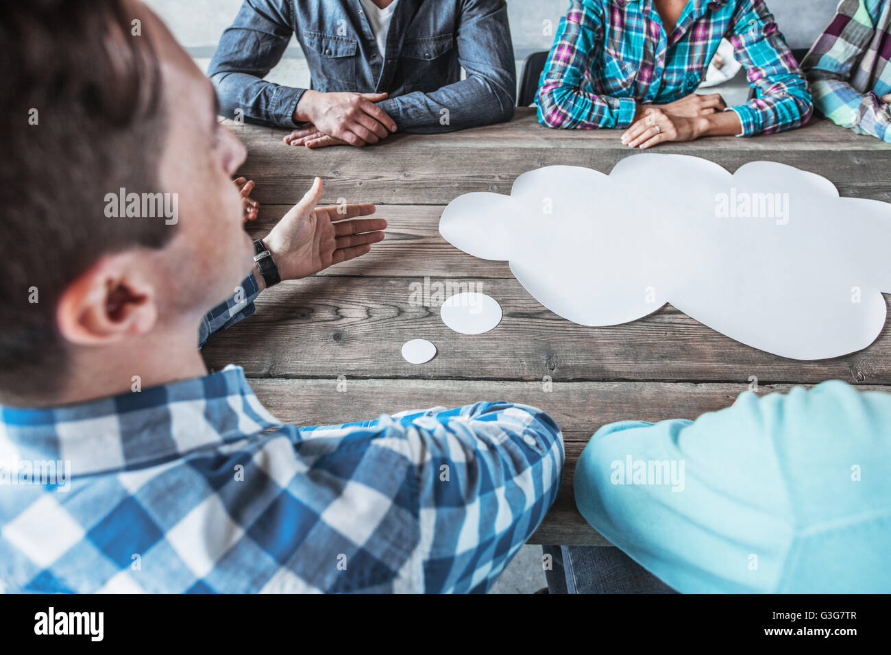 Business people sitting around the table with talking speech bubbles ...
