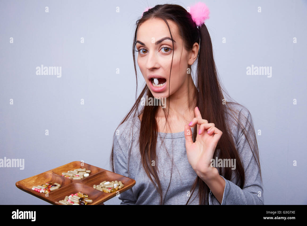 fun girl drinks a lot of pills Stock Photo - Alamy