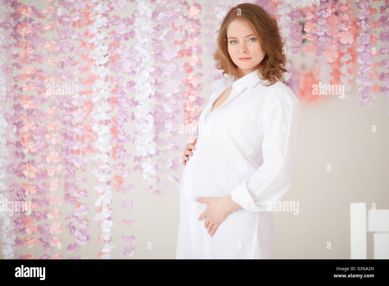 pregnant woman in pink on a background of flowers Stock Photo - Alamy