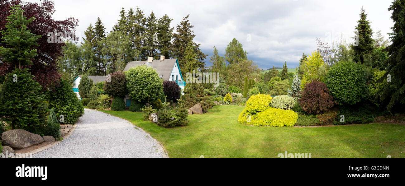 Beautiful luxury house situated in in spring garden, with conifers ...
