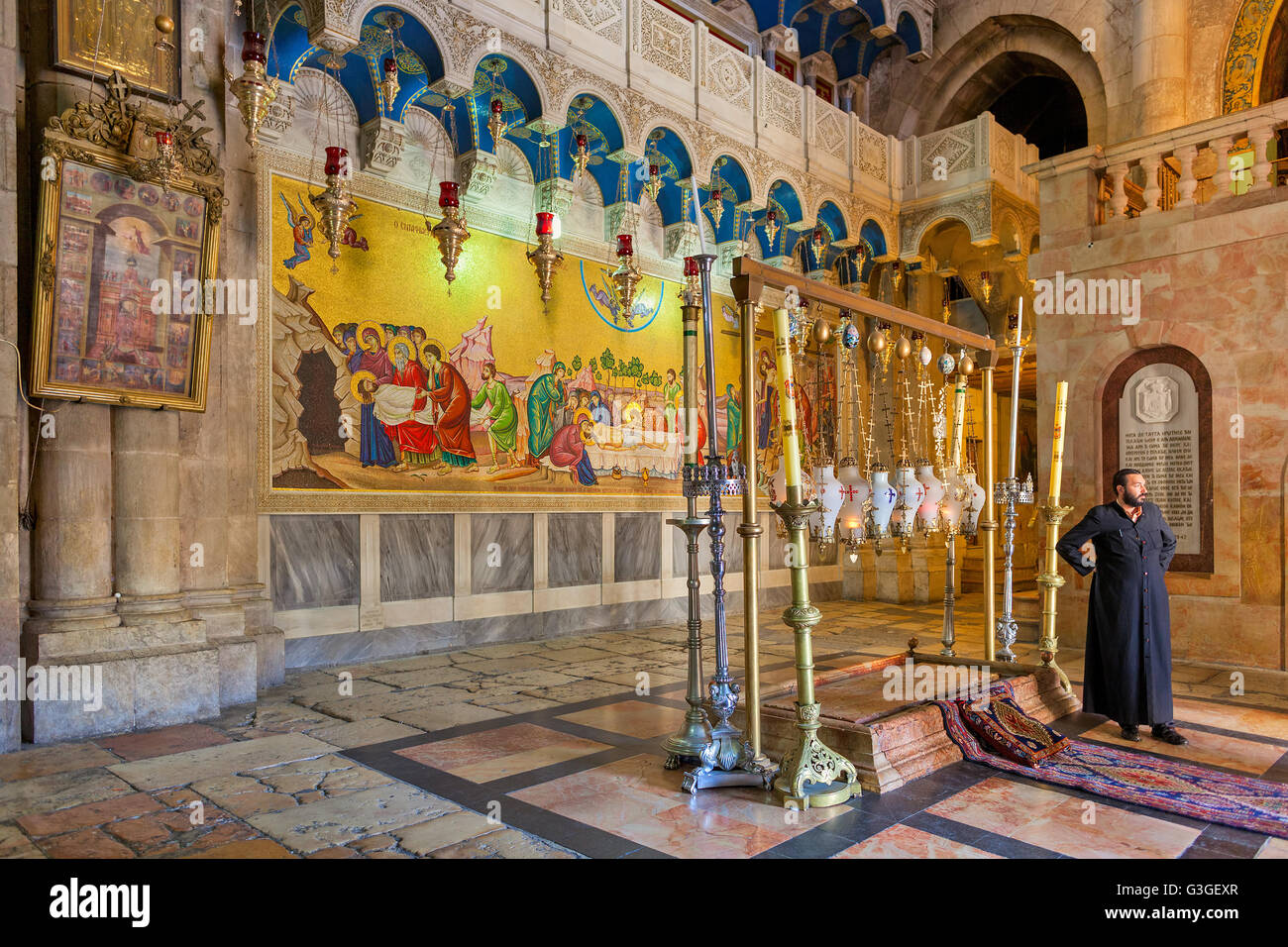 Stone of Anointing and mosaic icon on the wall at the entrance to Holy ...