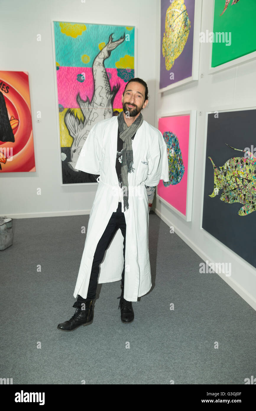 Adrien Brody poses in front of his paintings during preview at Art New ...